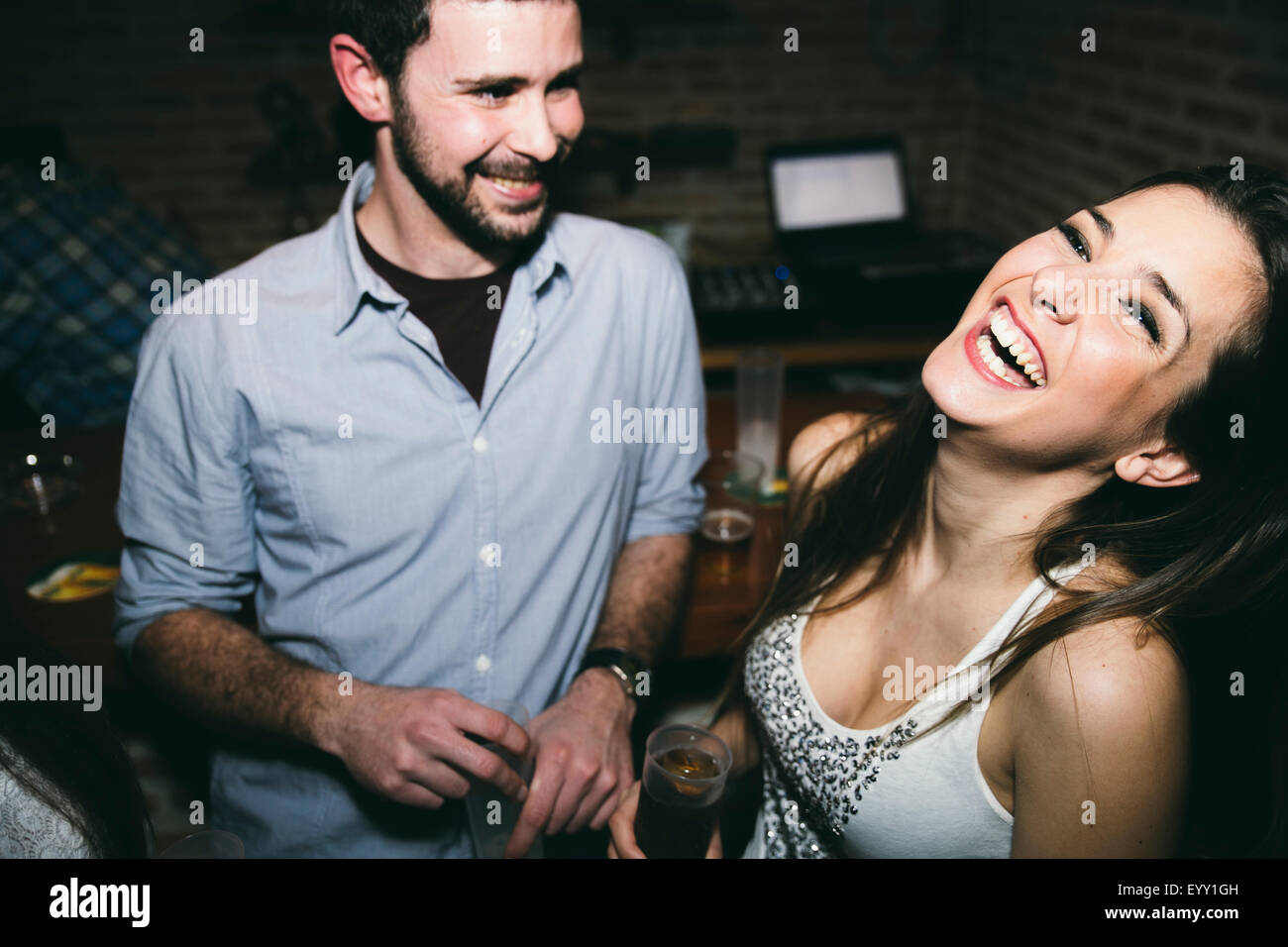 Couple laughing and drinking in nightclub Stock Photo - Alamy