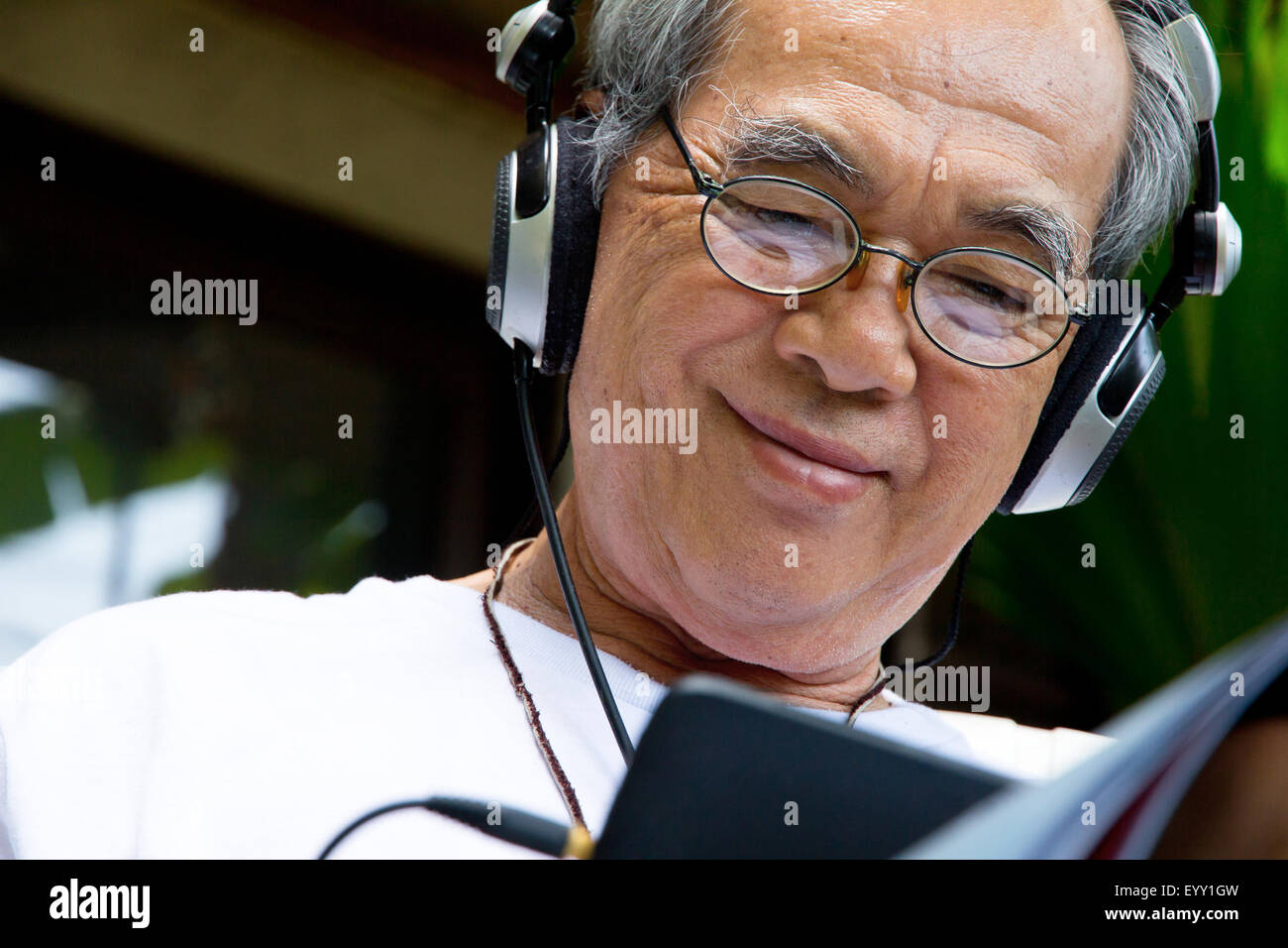 Senior man enjoying music on his tablet Stock Photo - Alamy