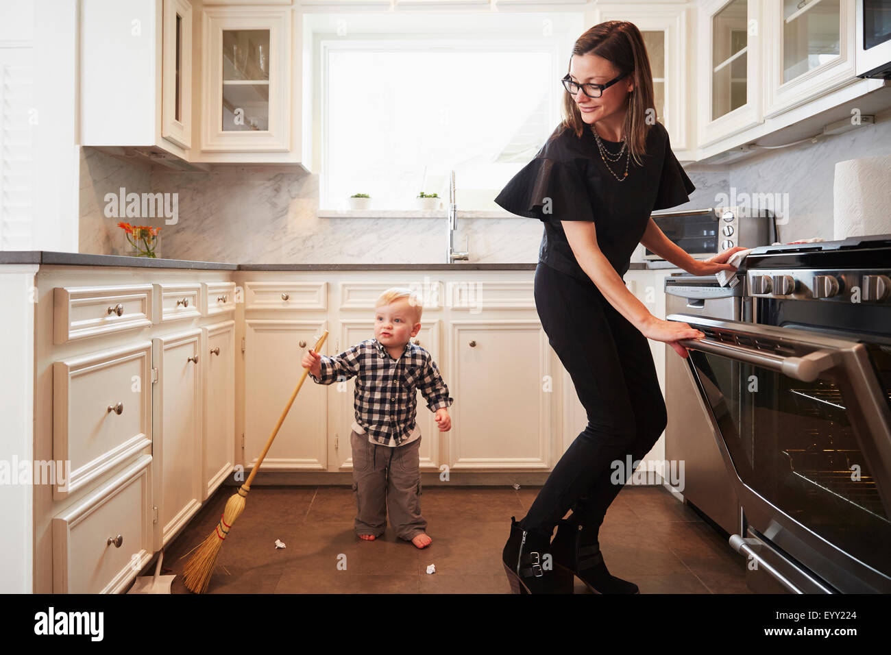 Child sweeping with mother hi-res stock photography and images - Alamy
