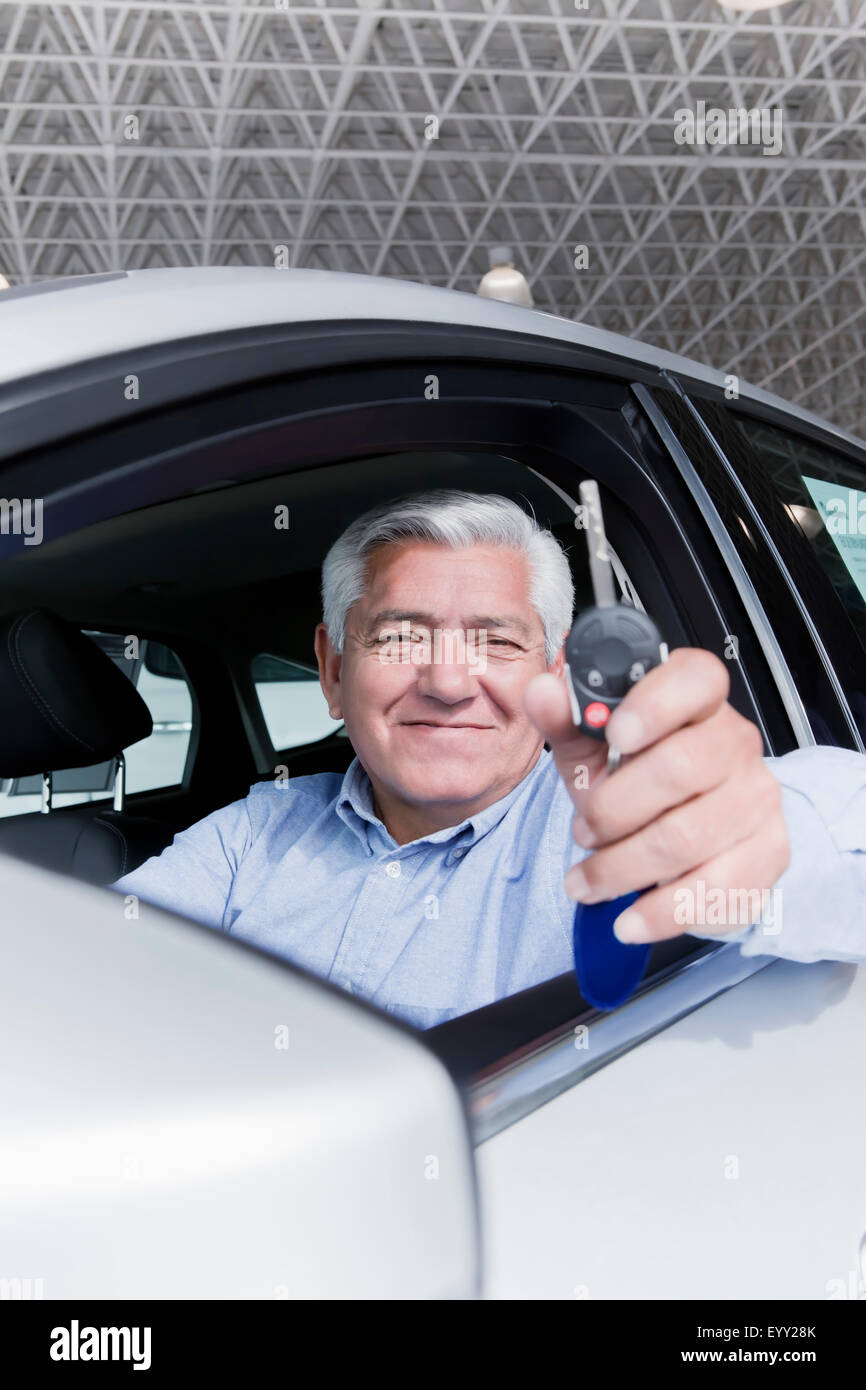 Hispanic man holding keys to new car Stock Photo - Alamy