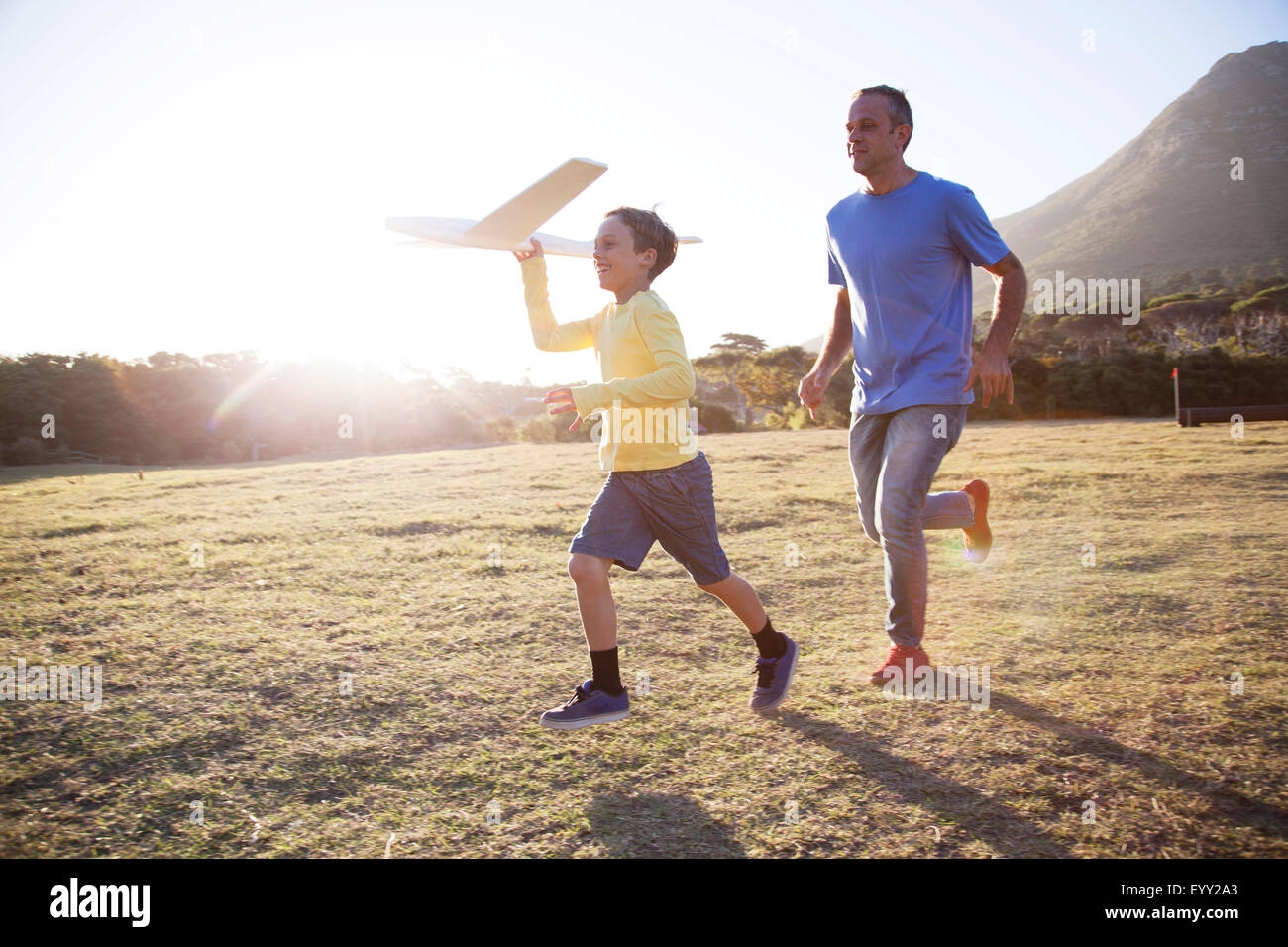 Caucasian father and son flying model airplane in field Stock Photo - Alamy