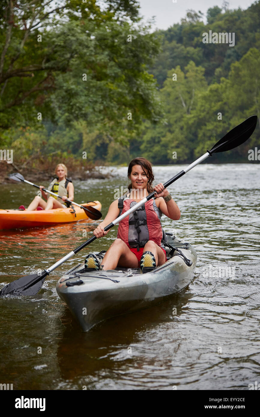 Women paddling kayaks in remote river Stock Photo - Alamy