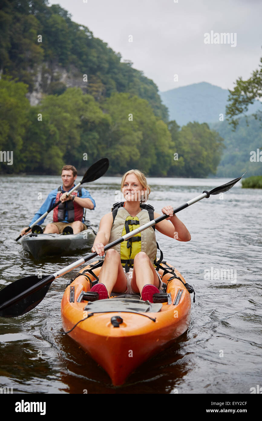 Caucasian couple paddling kayaks in remote river Stock Photo - Alamy