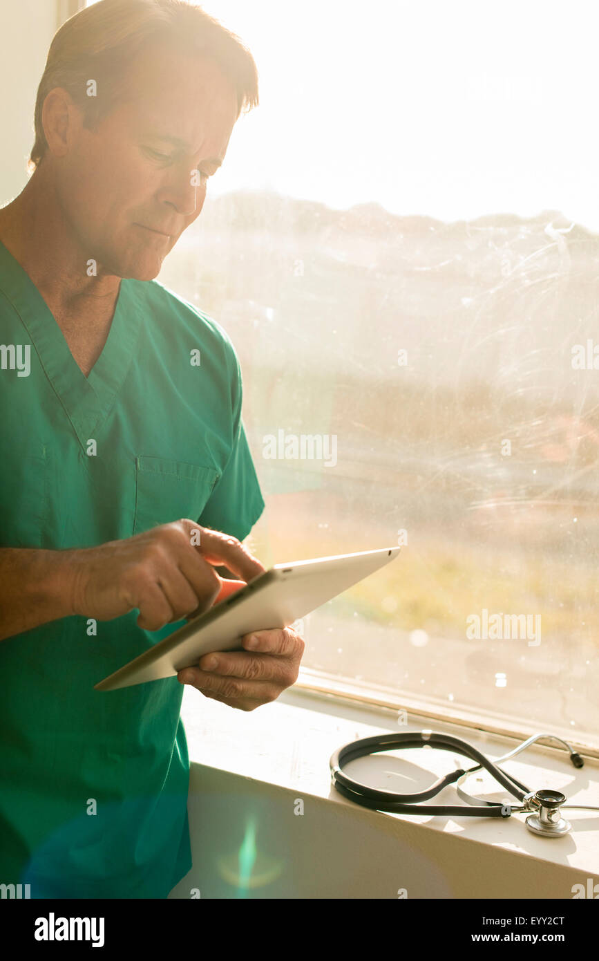 Caucasian nurse using digital tablet near window Stock Photo - Alamy