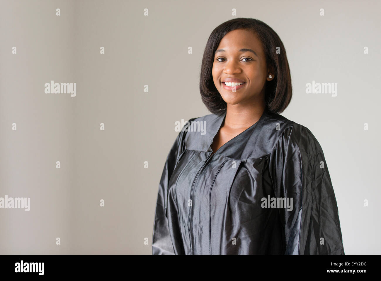 Mixed race graduate smiling in graduation robe Stock Photo - Alamy