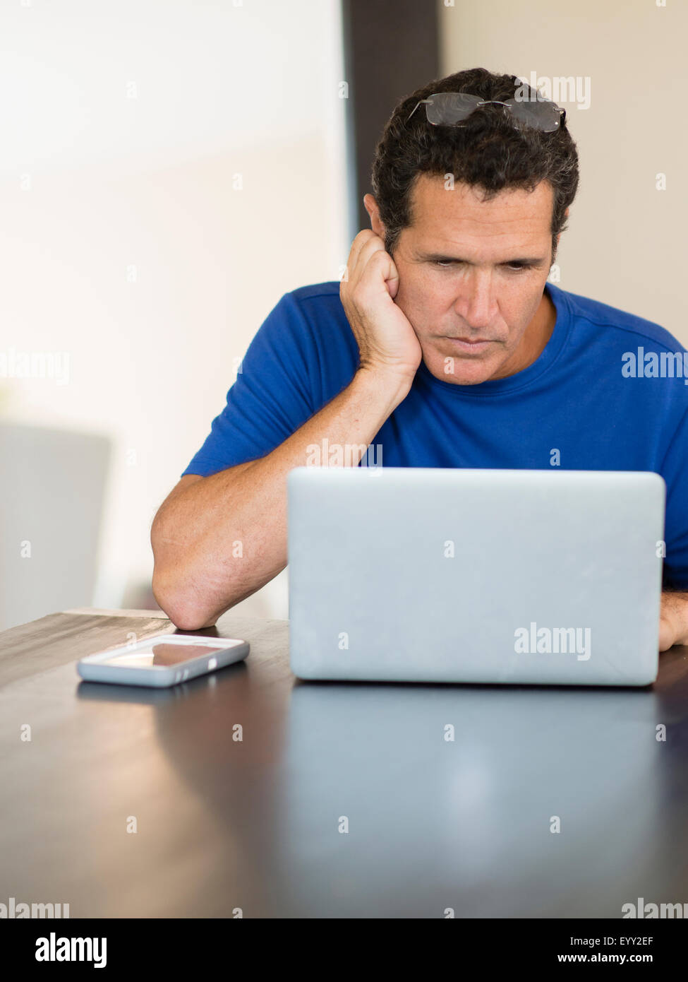 Hispanic man using laptop at table Stock Photo - Alamy