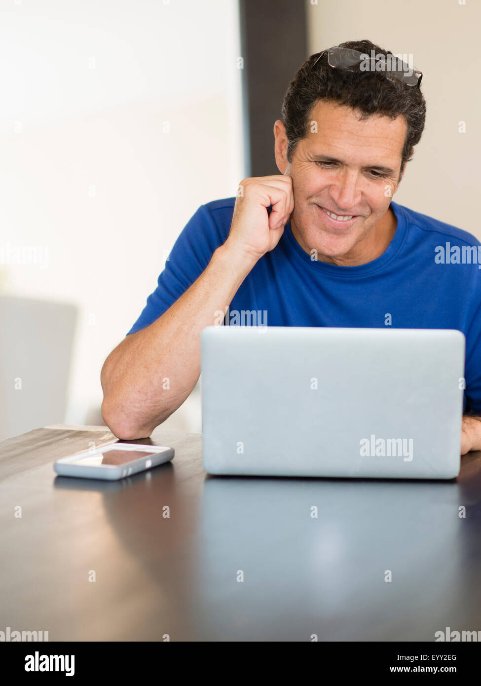 Hispanic man using laptop at table Stock Photo - Alamy