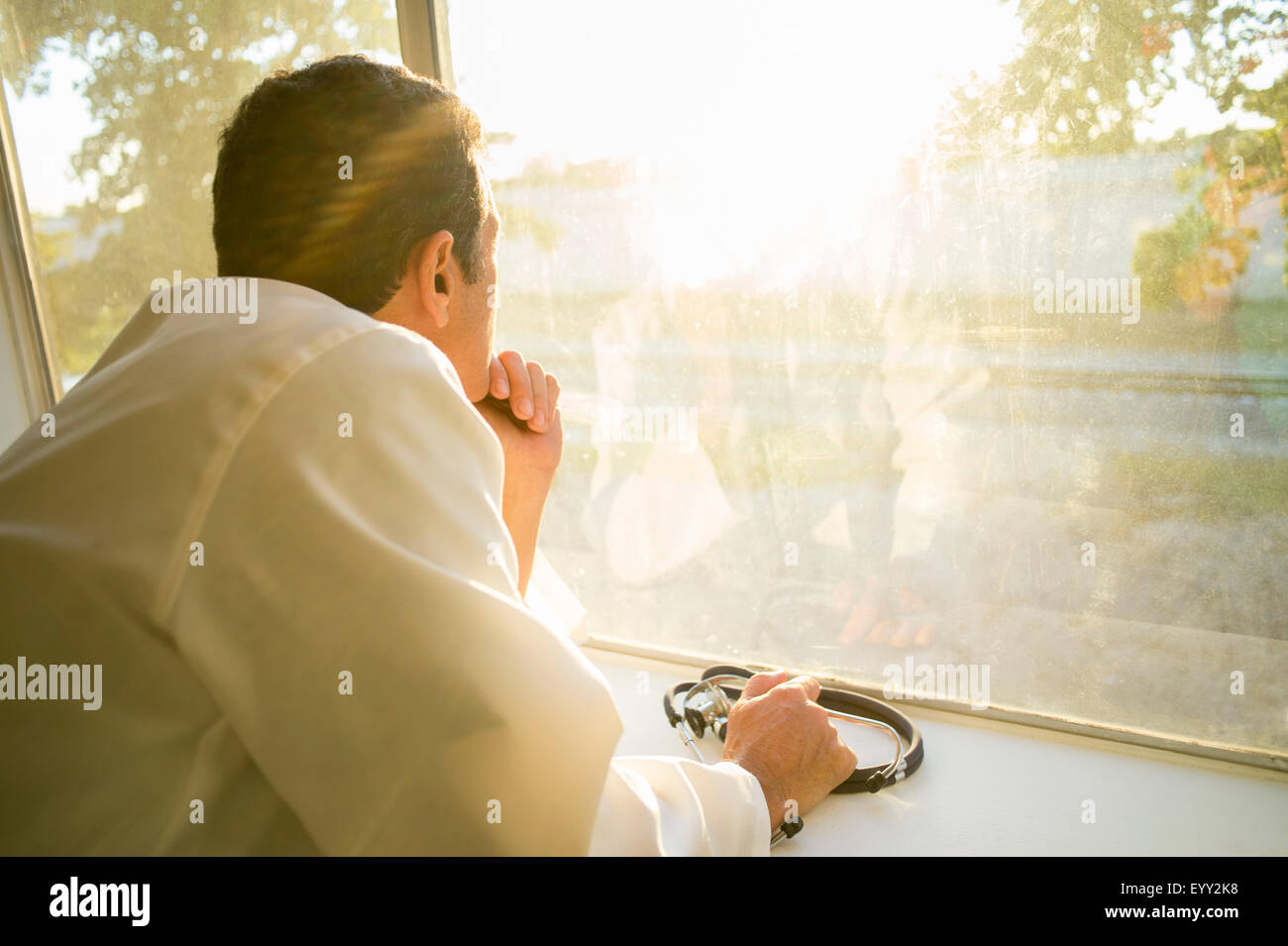 Hispanic doctor looking out window Stock Photo - Alamy
