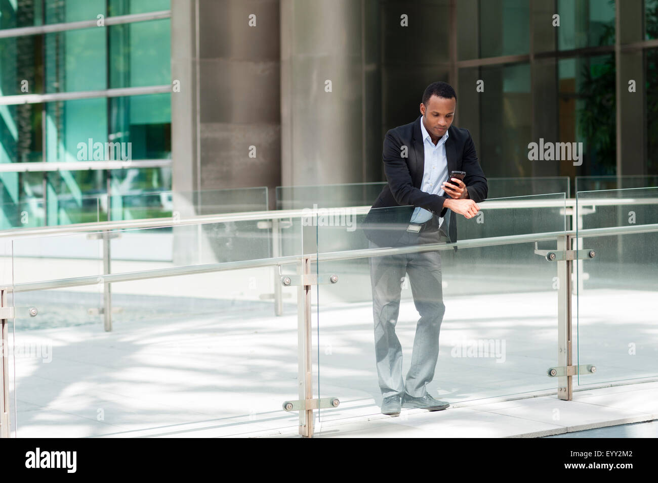 Black businessman using cell phone outside building Stock Photo - Alamy
