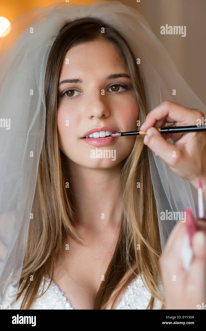 Caucasian stylist applying makeup on bride Stock Photo - Alamy