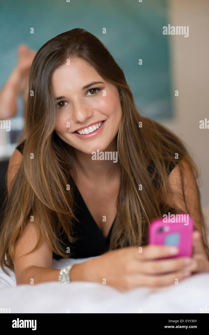 Caucasian woman using cell phone on bed Stock Photo - Alamy