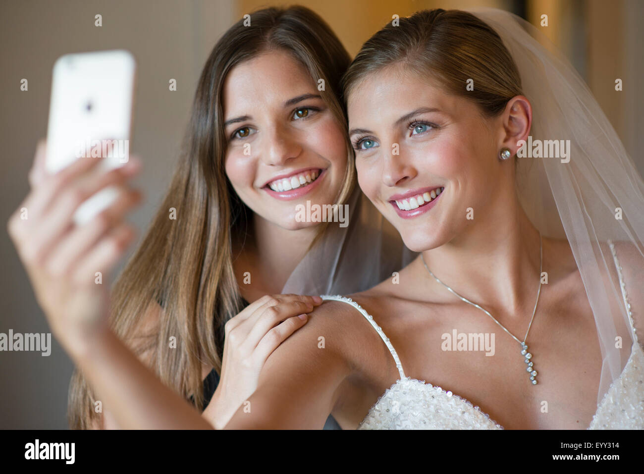 Caucasian bride and bridesmaid taking selfie Stock Photo - Alamy