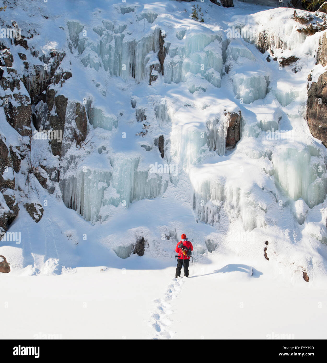 Ice climber walking toward frozen rock formations Stock Photo - Alamy