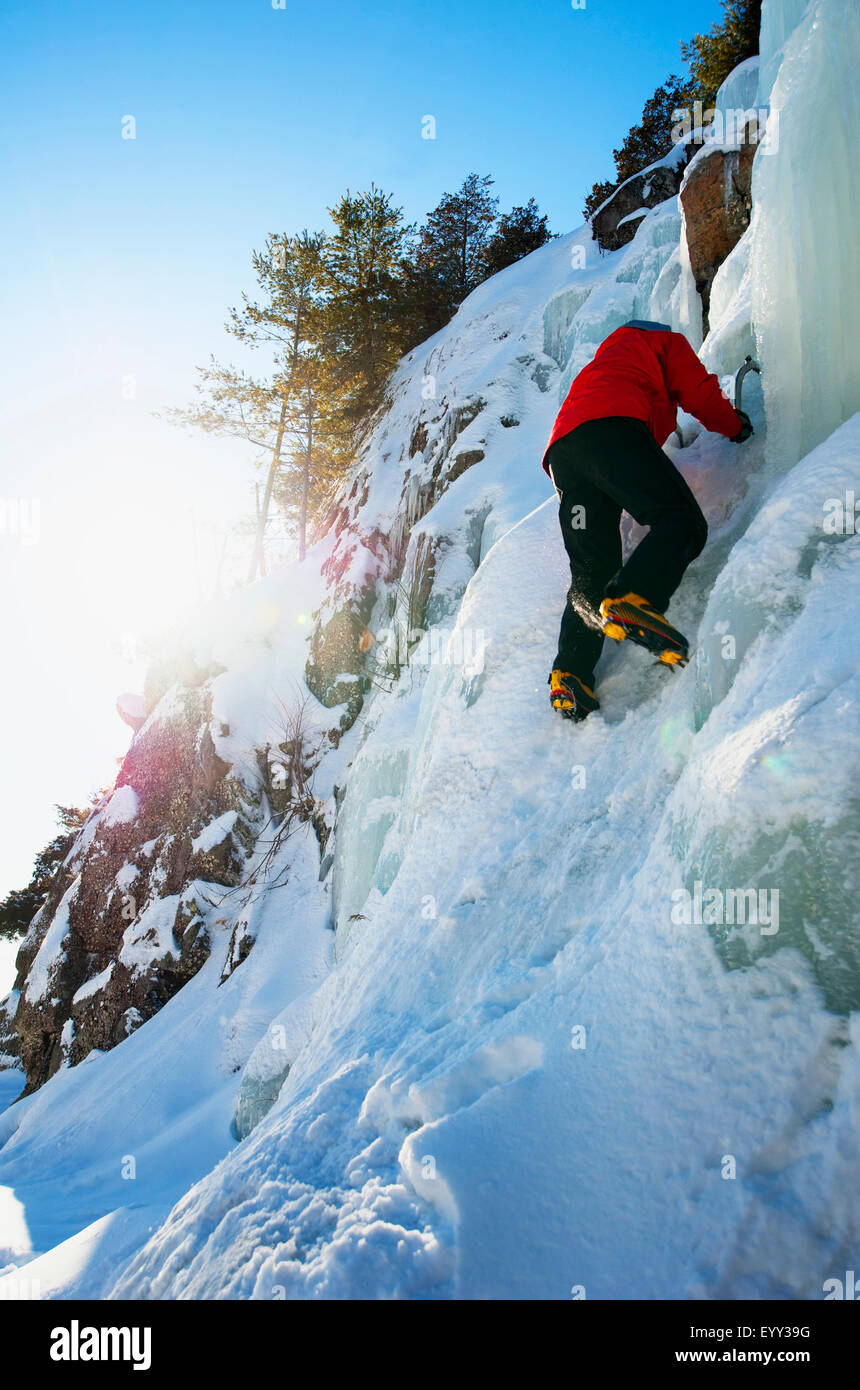 Ice climber scaling snowy frozen rock formations Stock Photo - Alamy
