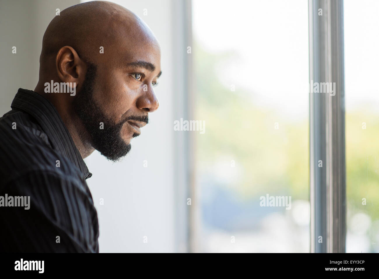Black man looking out window Stock Photo - Alamy