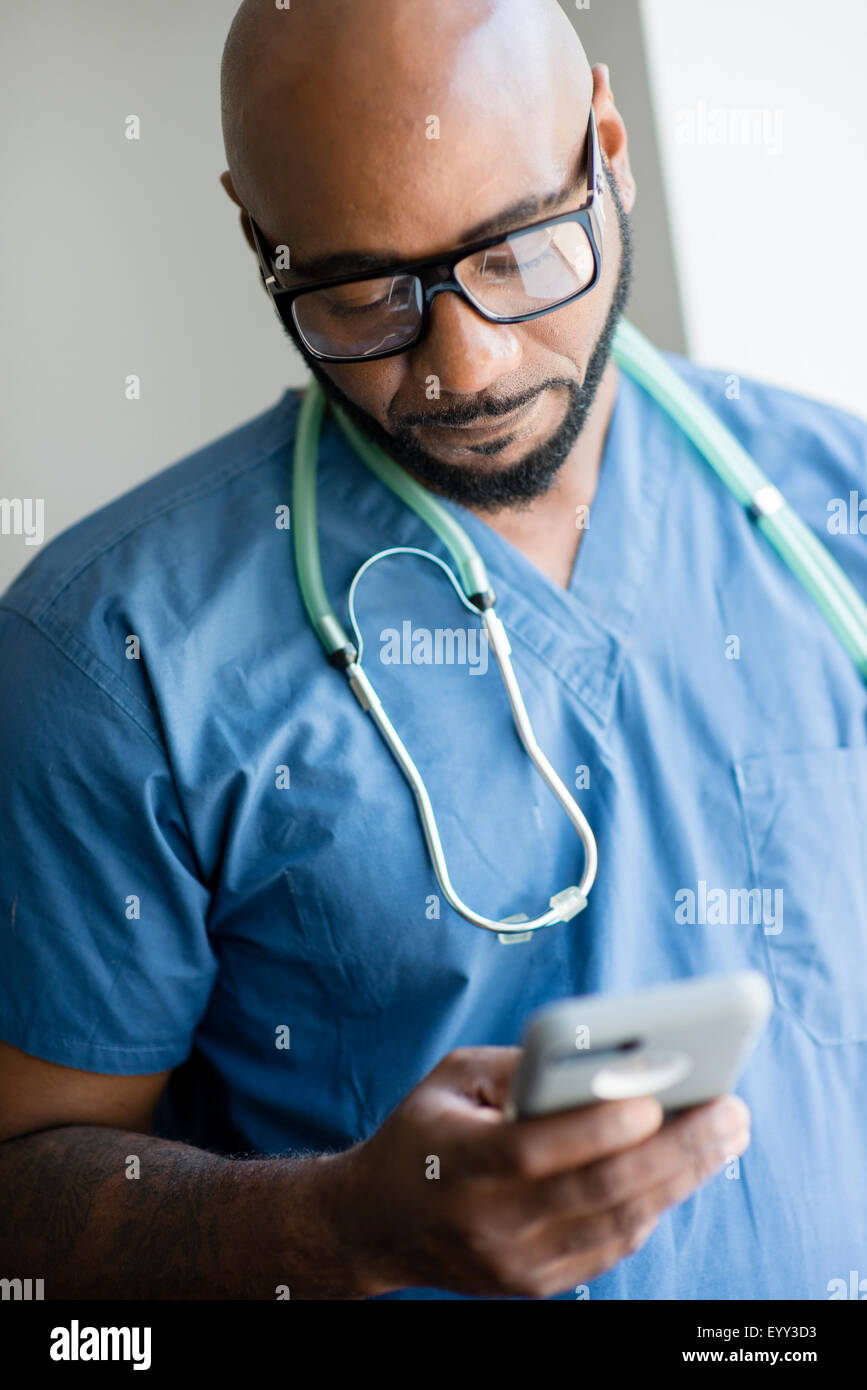 Black nurse using cell phone Stock Photo - Alamy