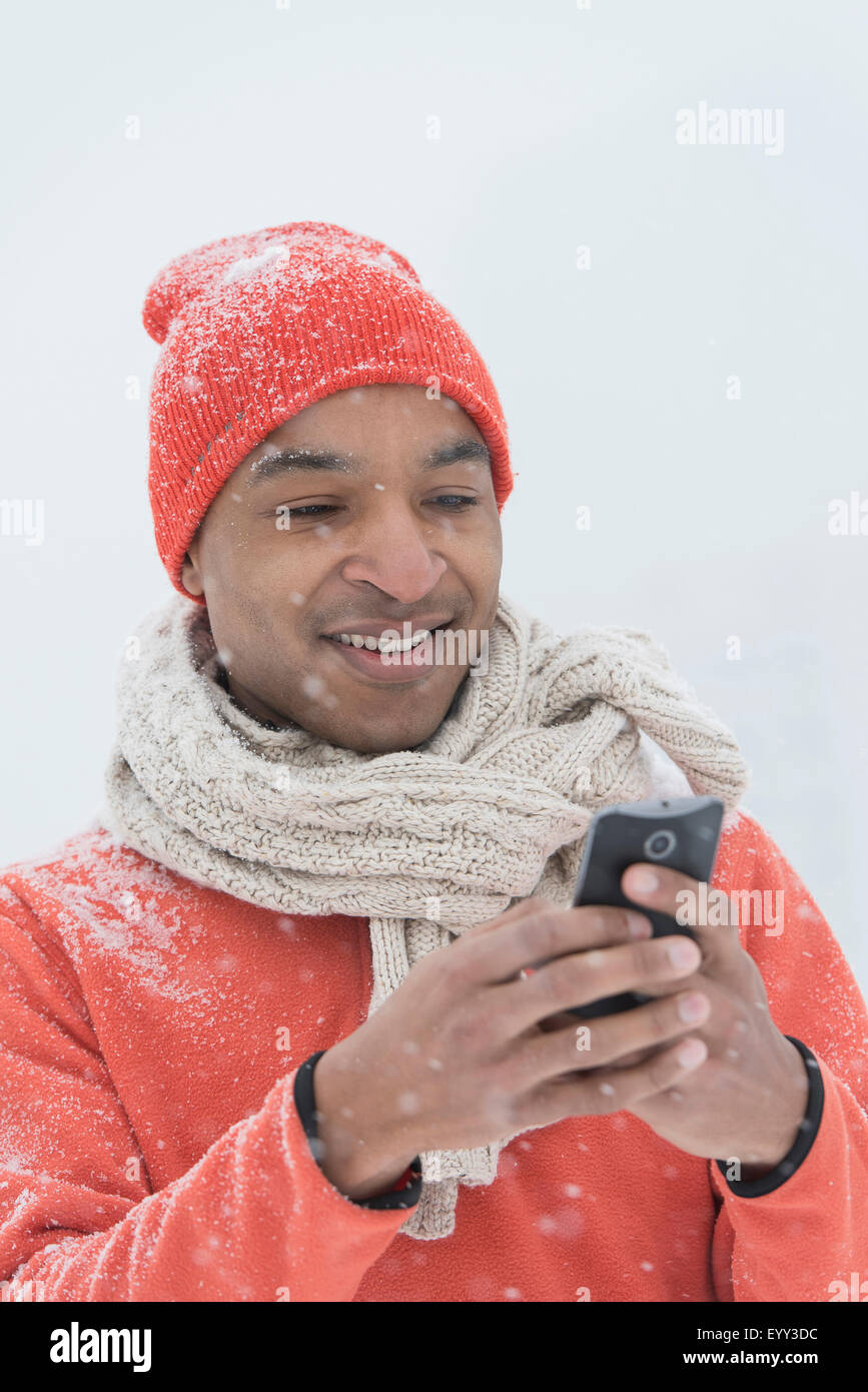 Black man using cell phone in snow Stock Photo - Alamy