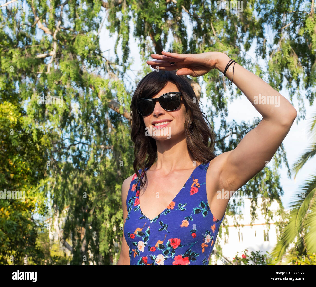 Hispanic woman shielding her eyes from sun Stock Photo - Alamy