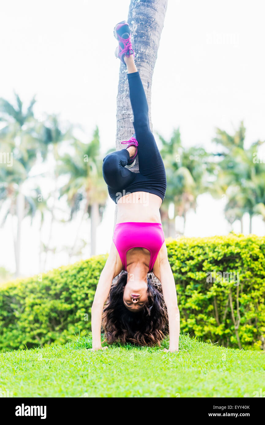 Chinese woman doing handstand against tree in park Stock Photo - Alamy