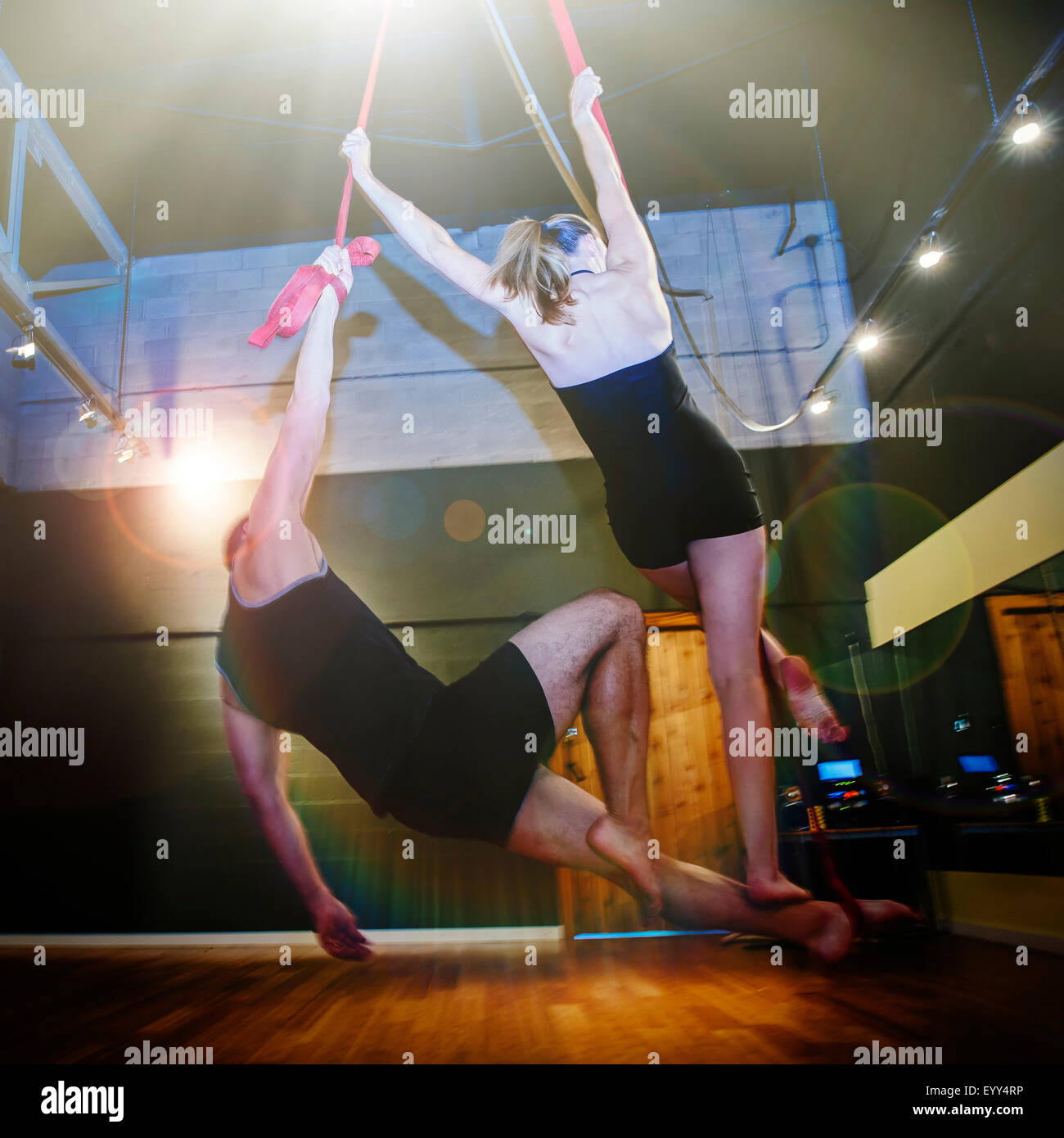 Caucasian acrobats hanging from ropes in studio Stock Photo - Alamy