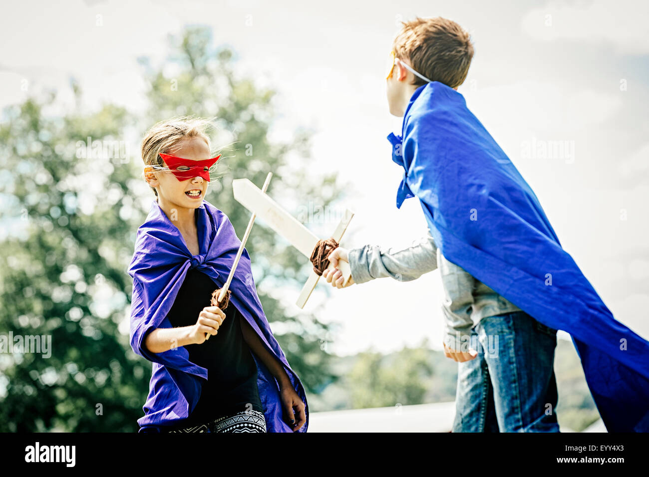 Caucasian children in costumes playing with swords Stock Photo - Alamy