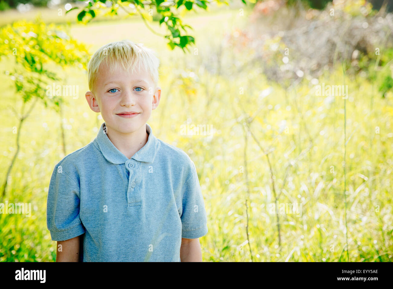 Caucasian boy smiling in tall grass Stock Photo - Alamy