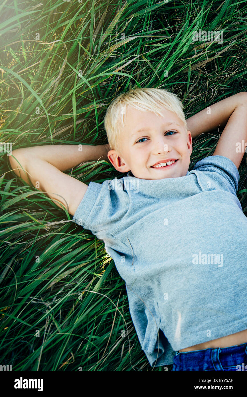 Caucasian boy laying in tall grass Stock Photo - Alamy