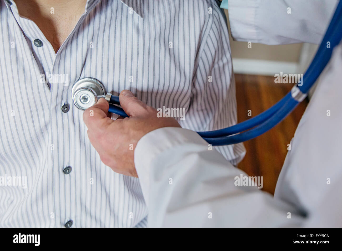Caucasian doctor listening to heartbeat of patient Stock Photo - Alamy