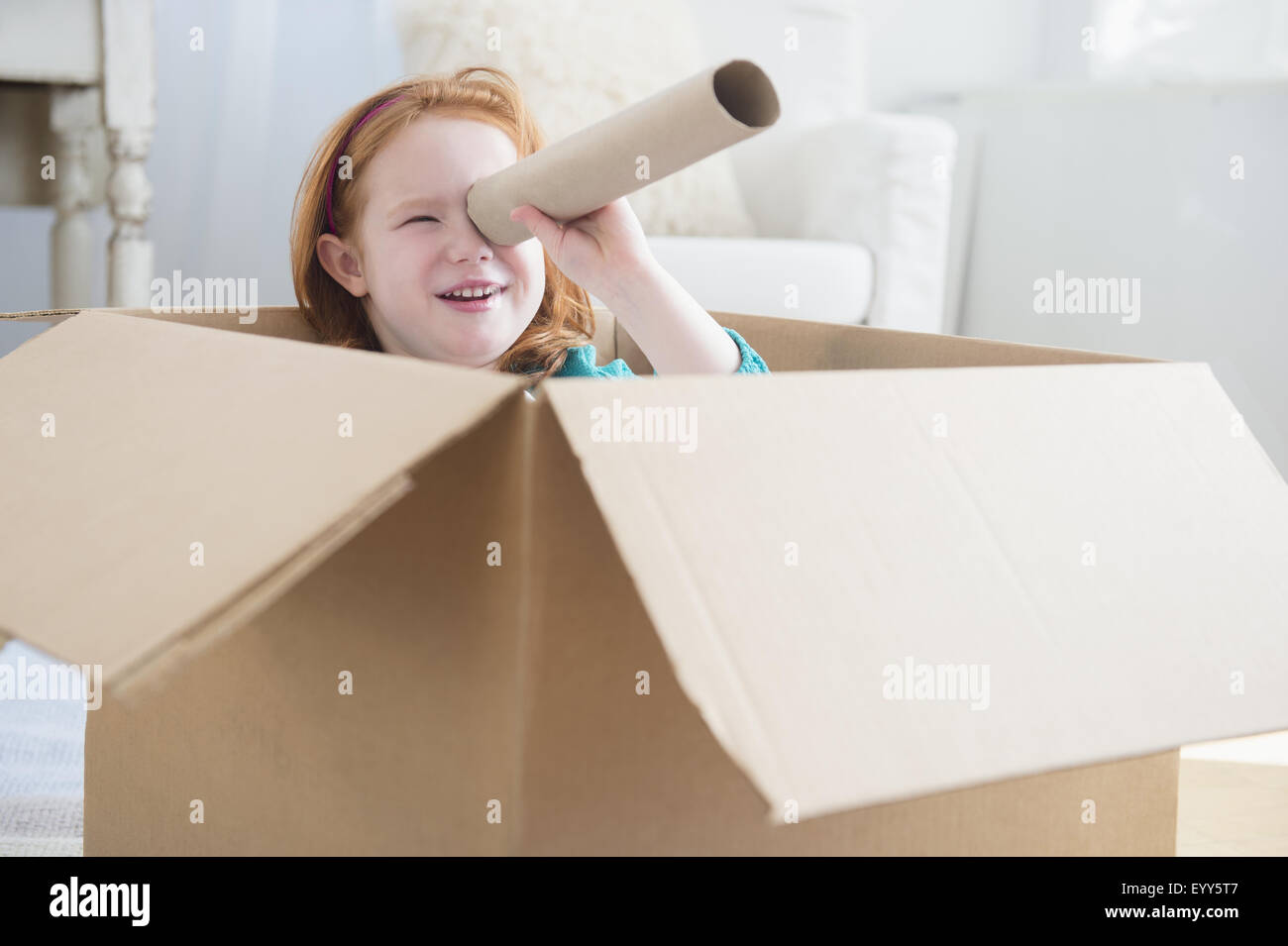 Caucasian girl playing in cardboard box Stock Photo - Alamy