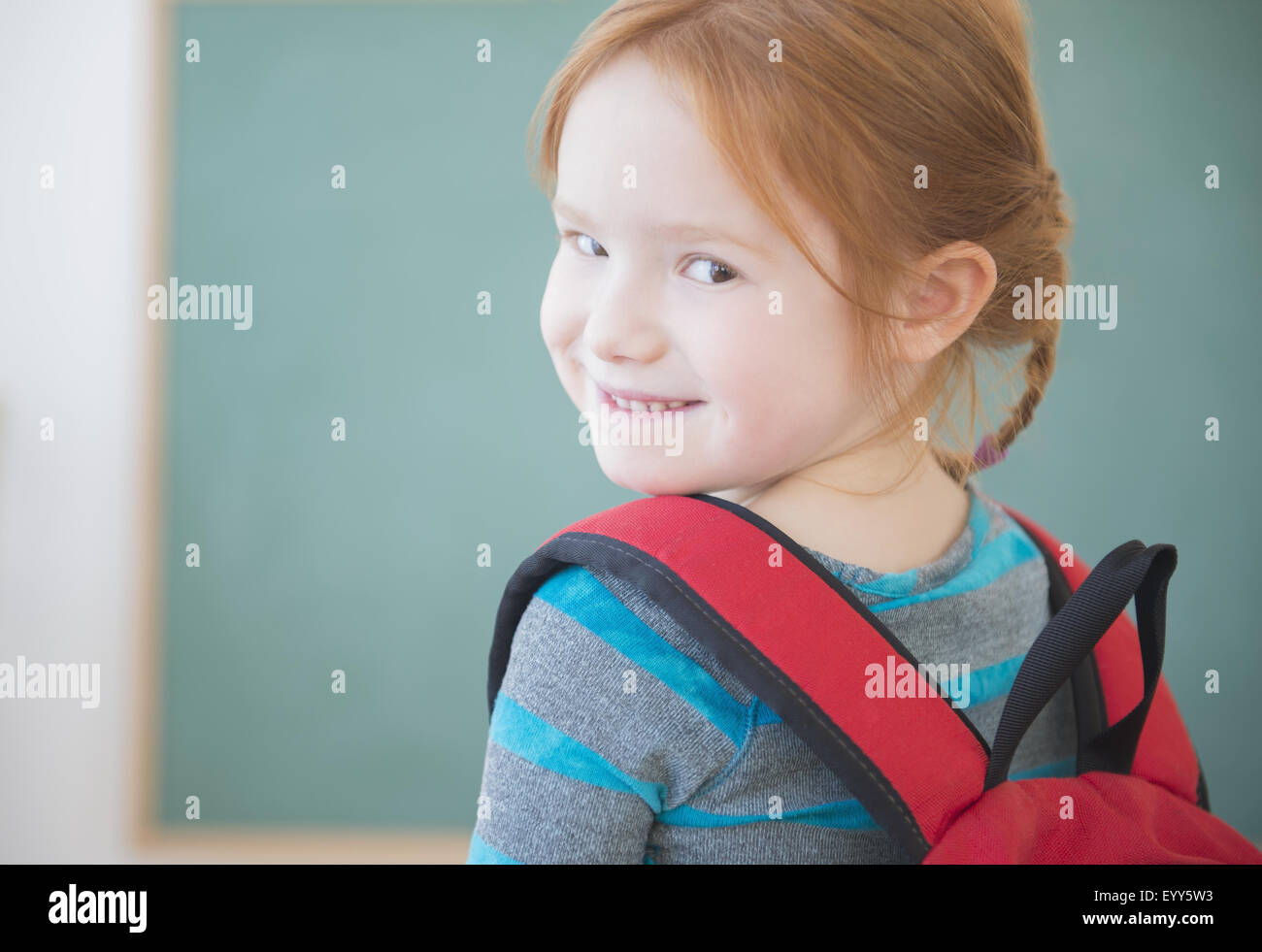 Caucasian girl wearing backpack in classroom Stock Photo - Alamy