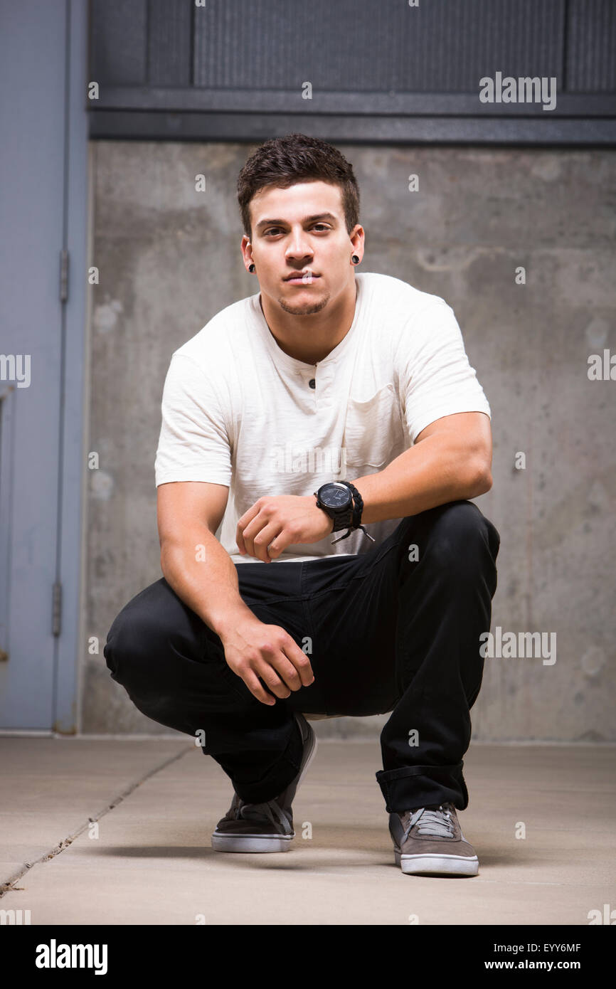 Pacific Islander man crouching on floor Stock Photo - Alamy