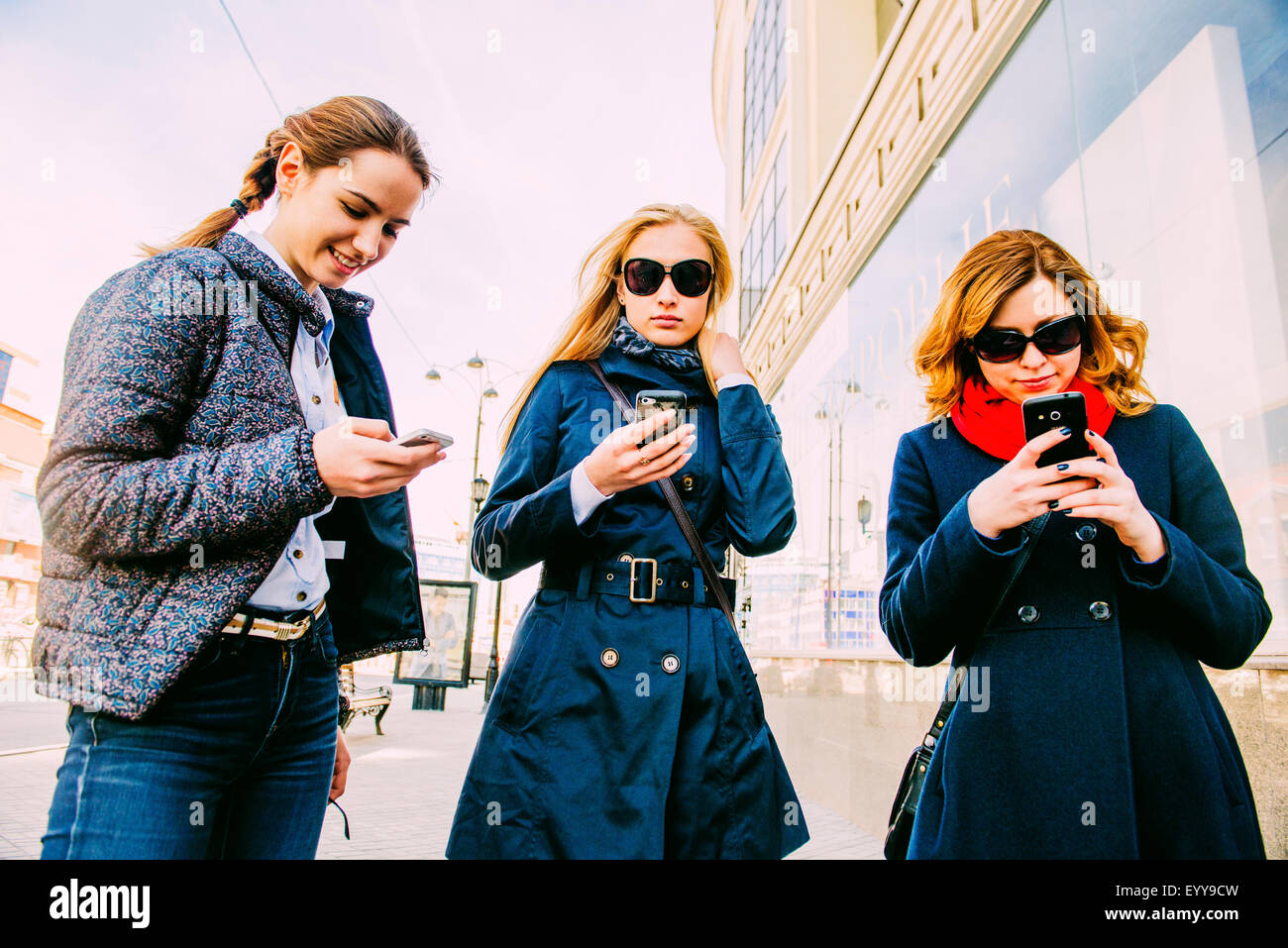 Caucasian women using cell phones in city Stock Photo - Alamy