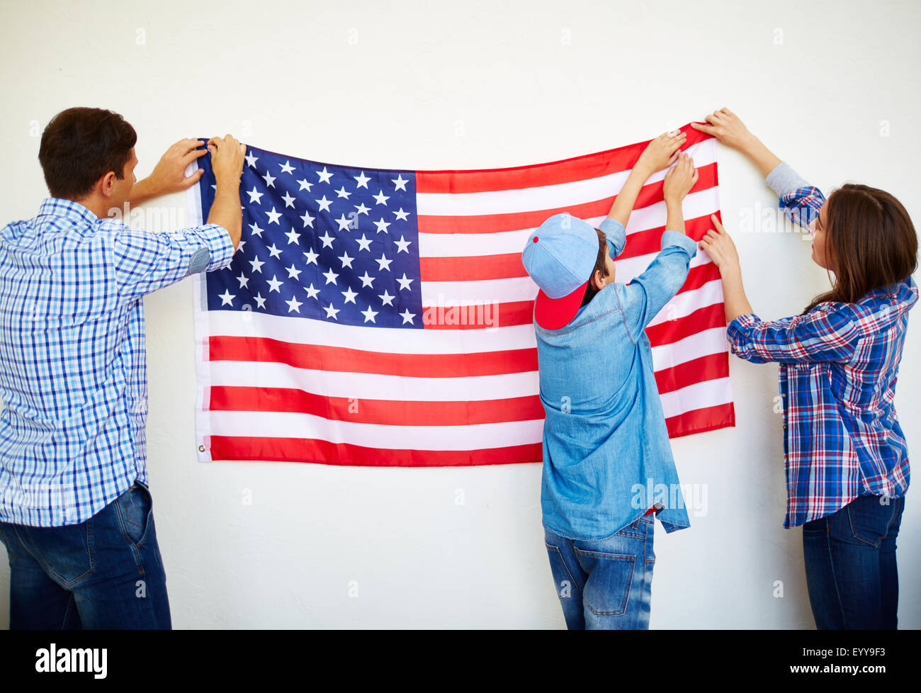 Family of three hanging USA flag on wall Stock Photo - Alamy