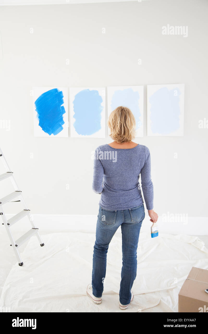 Caucasian woman examining paint samples in new home Stock Photo - Alamy
