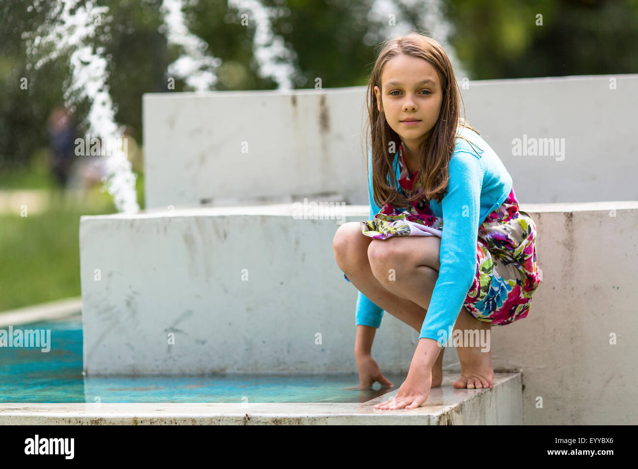Portrait of cute little girl in summer outdoors, near the fountains ...