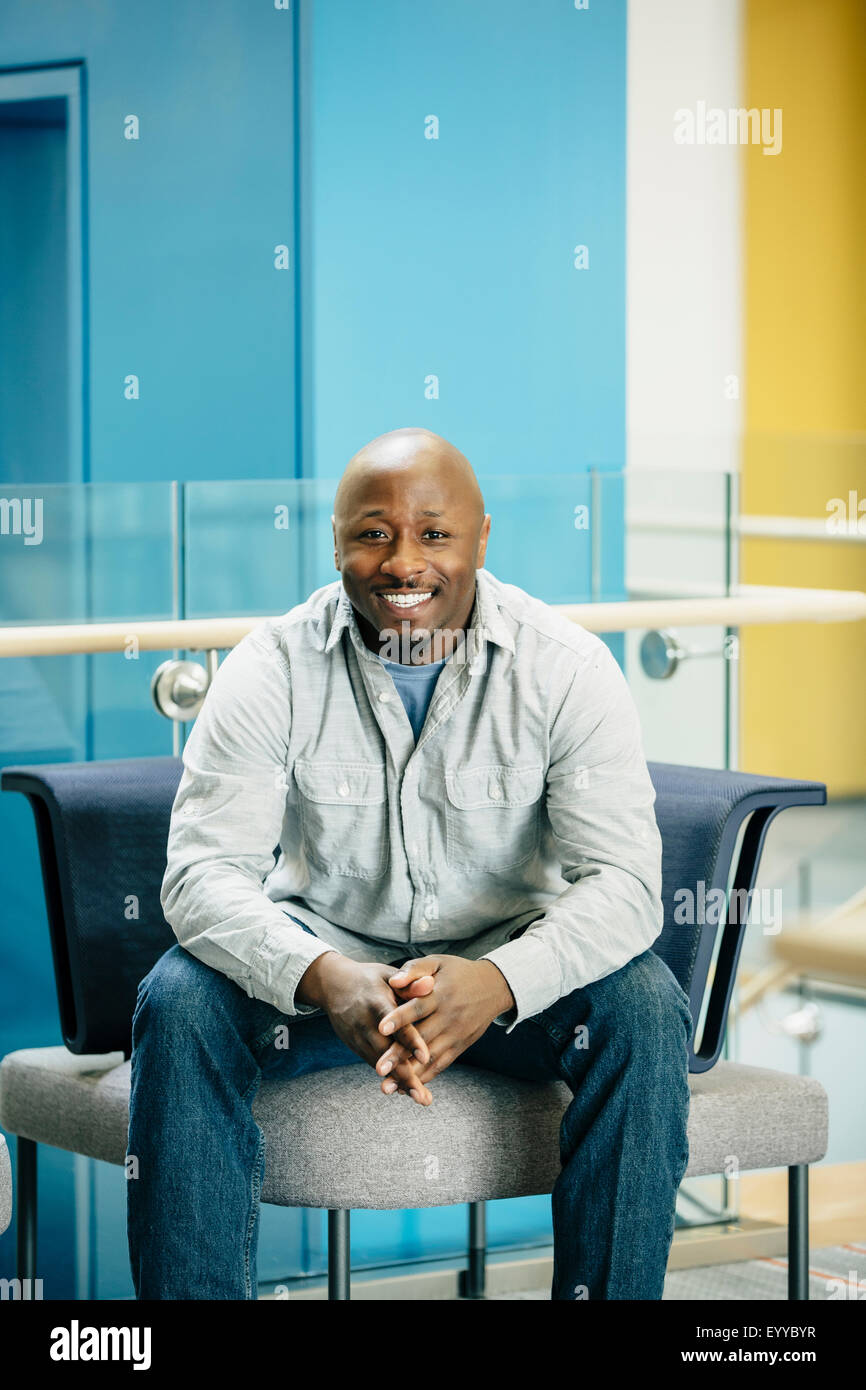 Black businessman smiling in office lobby Stock Photo - Alamy