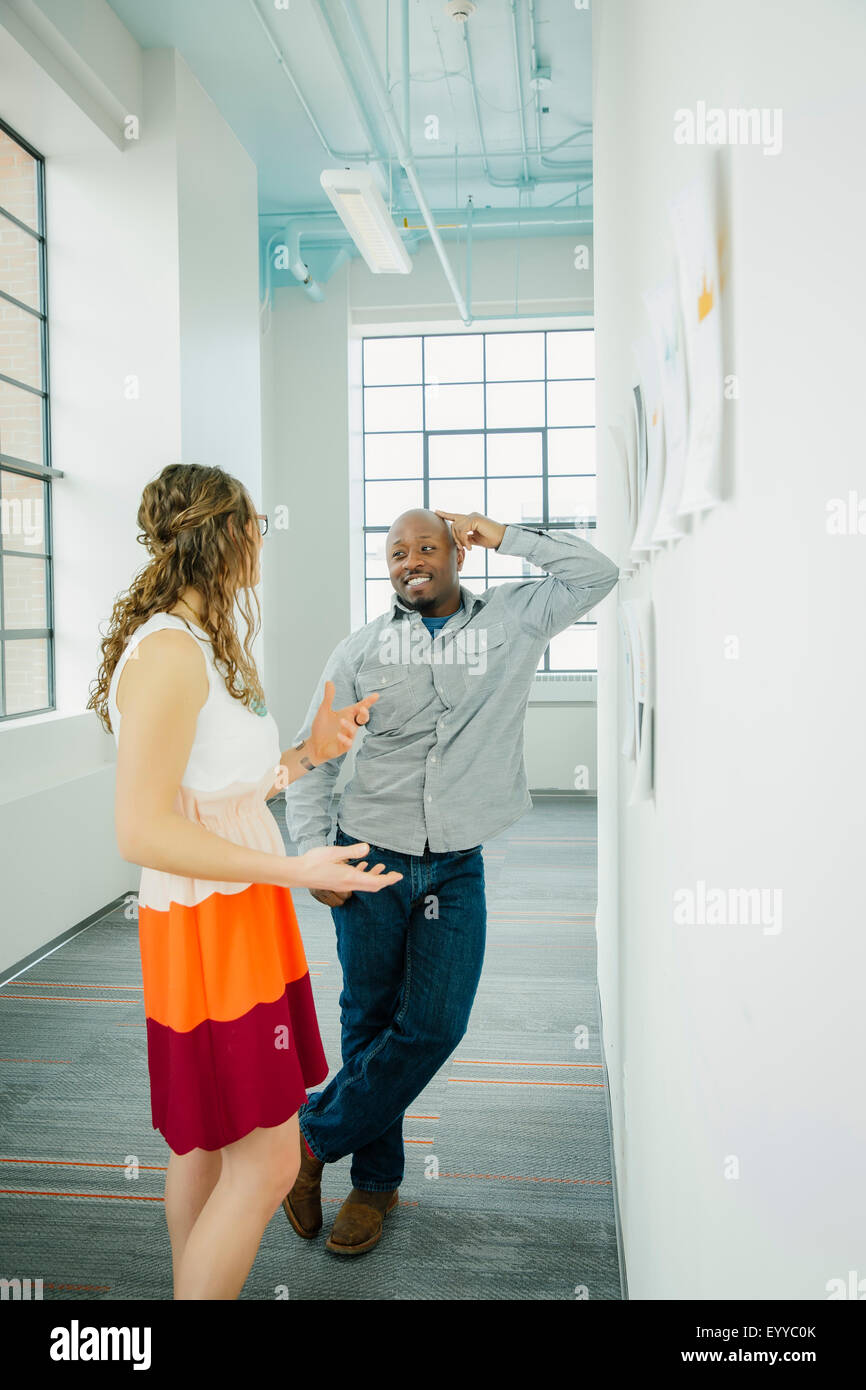 Business people discussing paperwork on office wall Stock Photo - Alamy