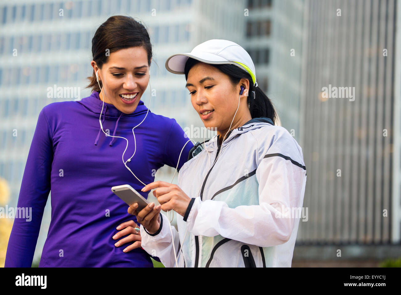 Runners using cell phone near high rise buildings Stock Photo - Alamy