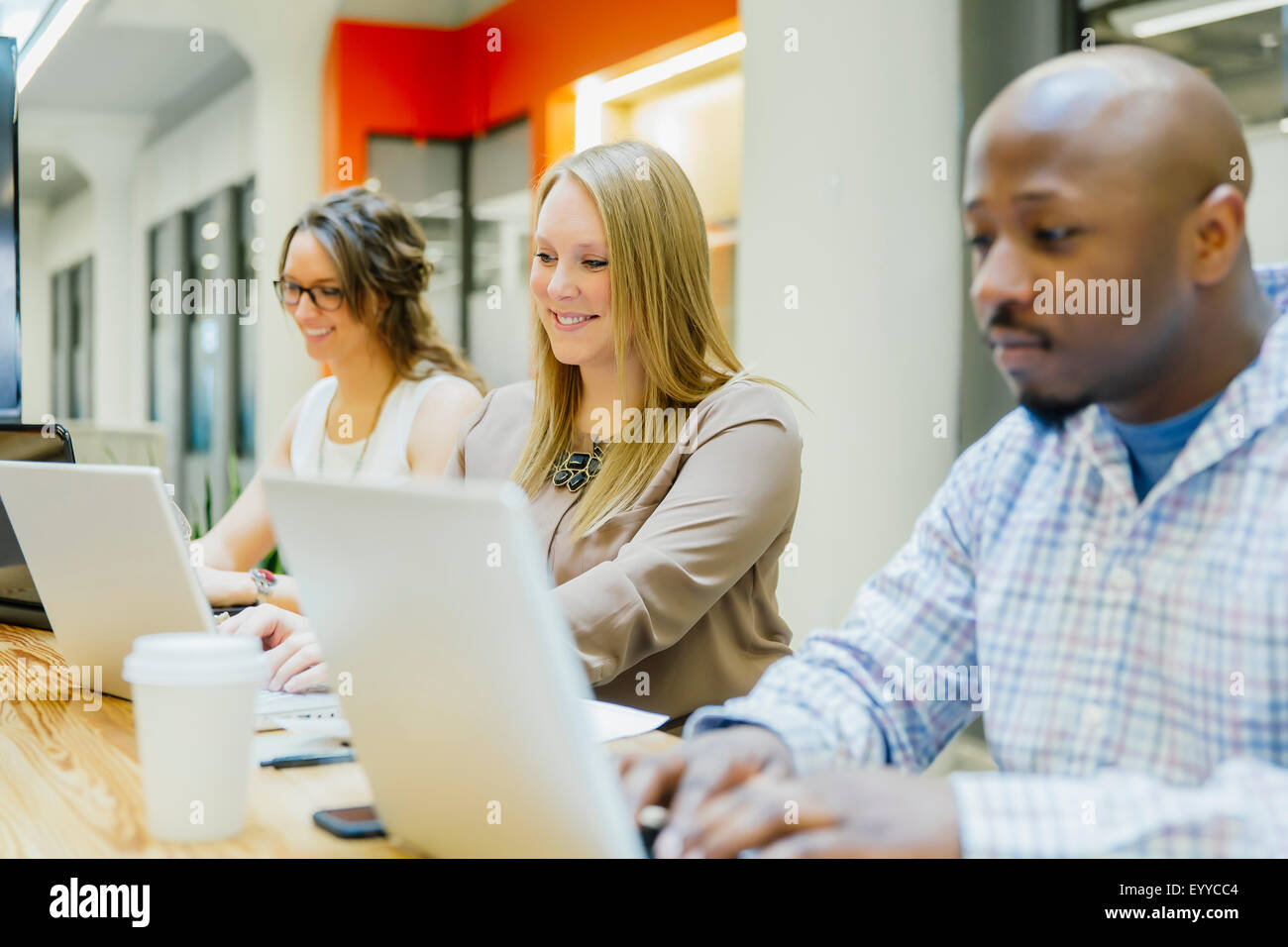 Business people working on laptops in office meeting Stock Photo - Alamy
