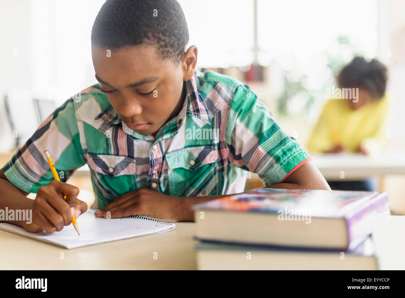 Black student writing in classroom Stock Photo - Alamy