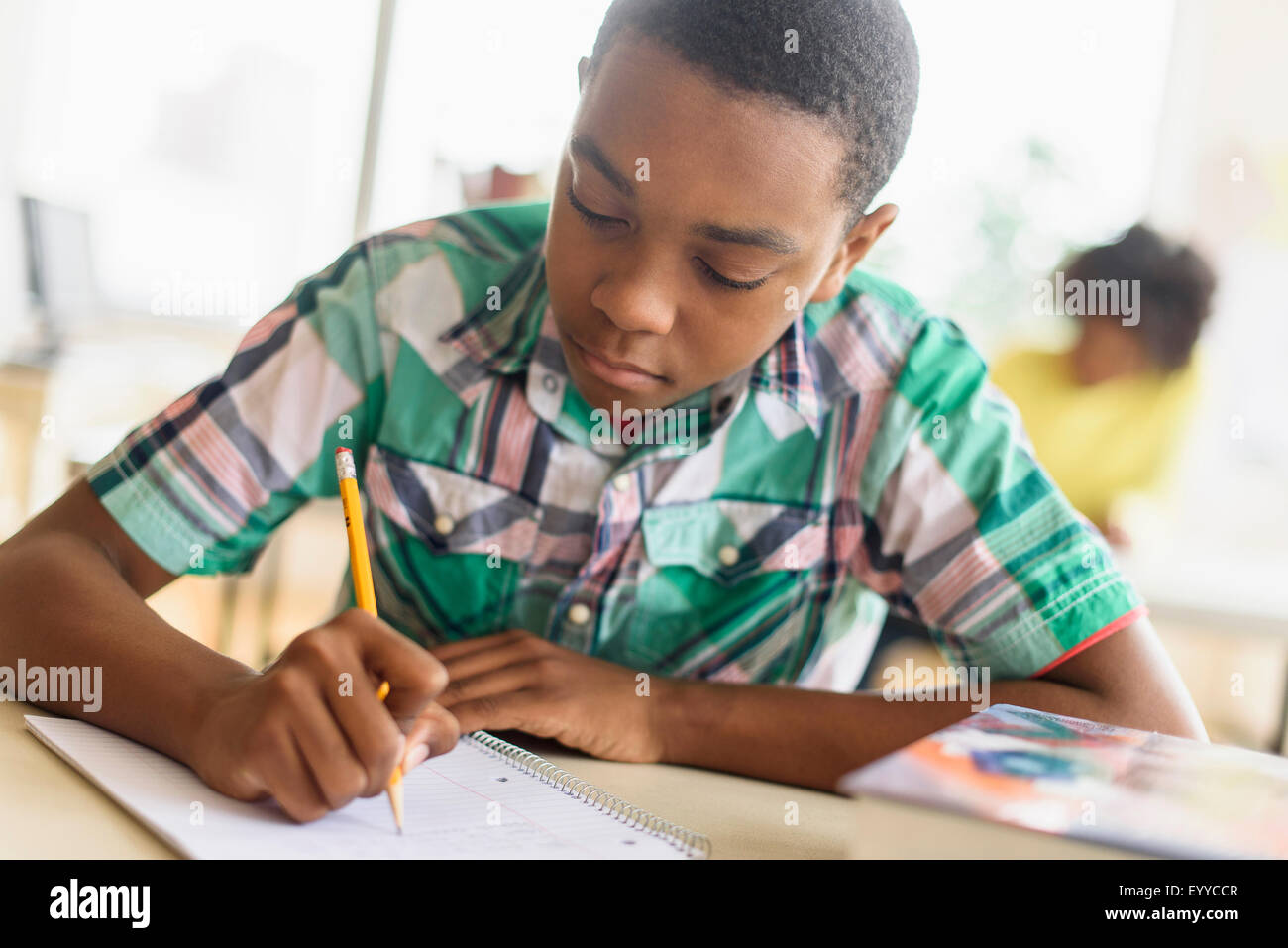 Black student writing in classroom Stock Photo - Alamy