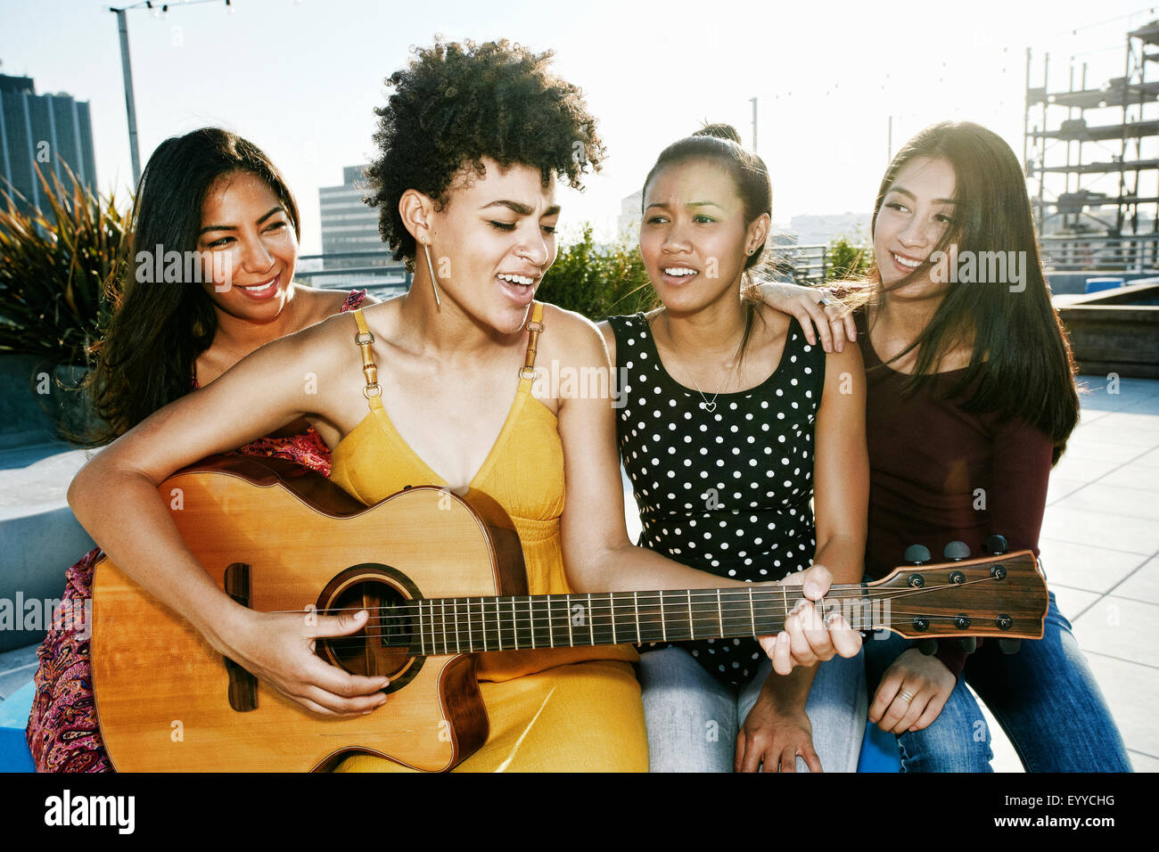 Women playing music and singing on urban rooftop Stock Photo - Alamy
