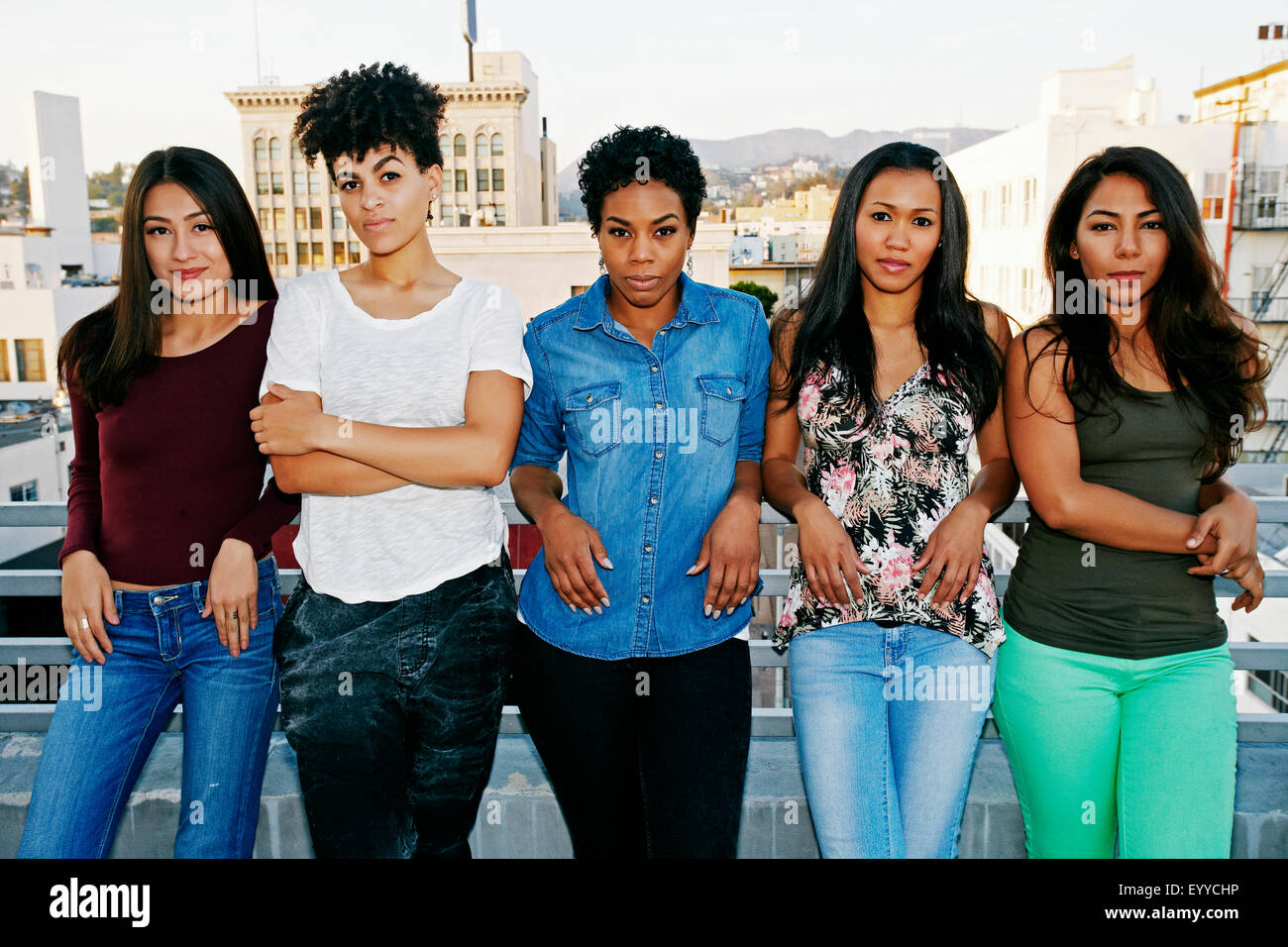 Serious women standing on urban rooftop Stock Photo - Alamy