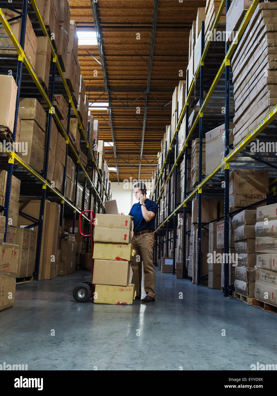 Caucasian worker using laptop in warehouse Stock Photo - Alamy