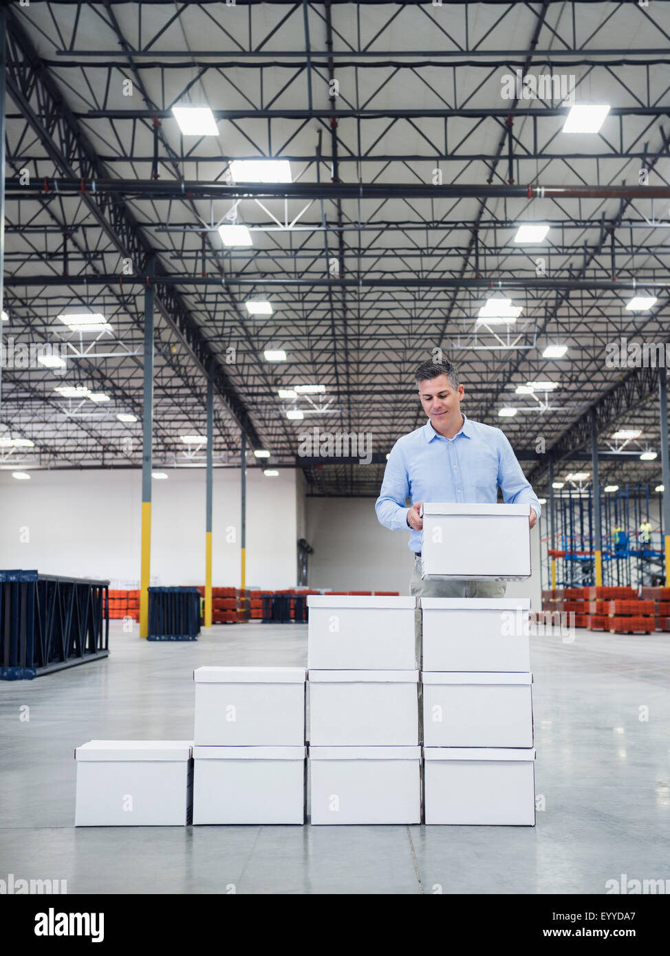 Caucasian businessman stacking boxes in warehouse Stock Photo - Alamy