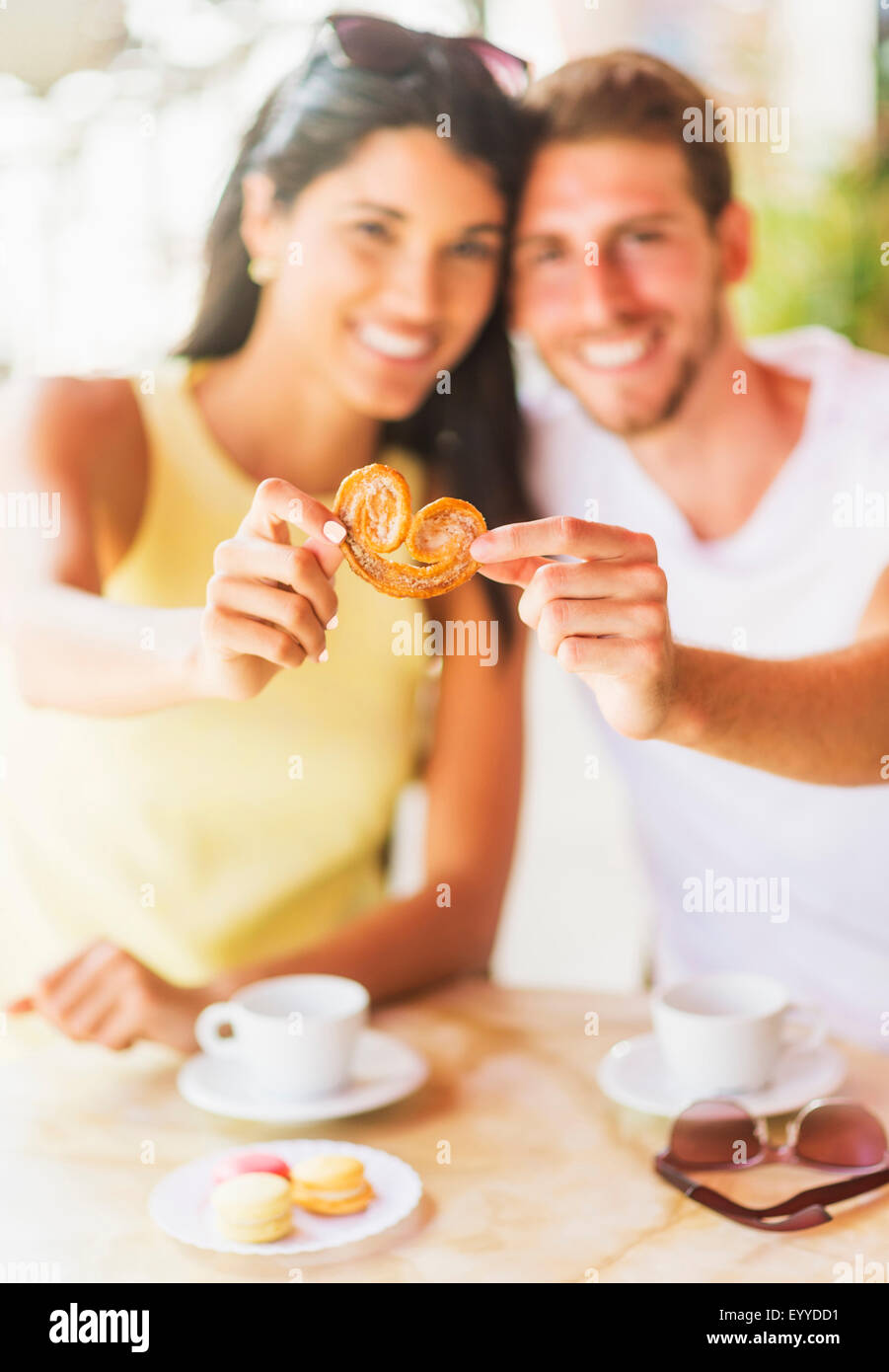 Hispanic couple sharing cookie at cafe Stock Photo - Alamy