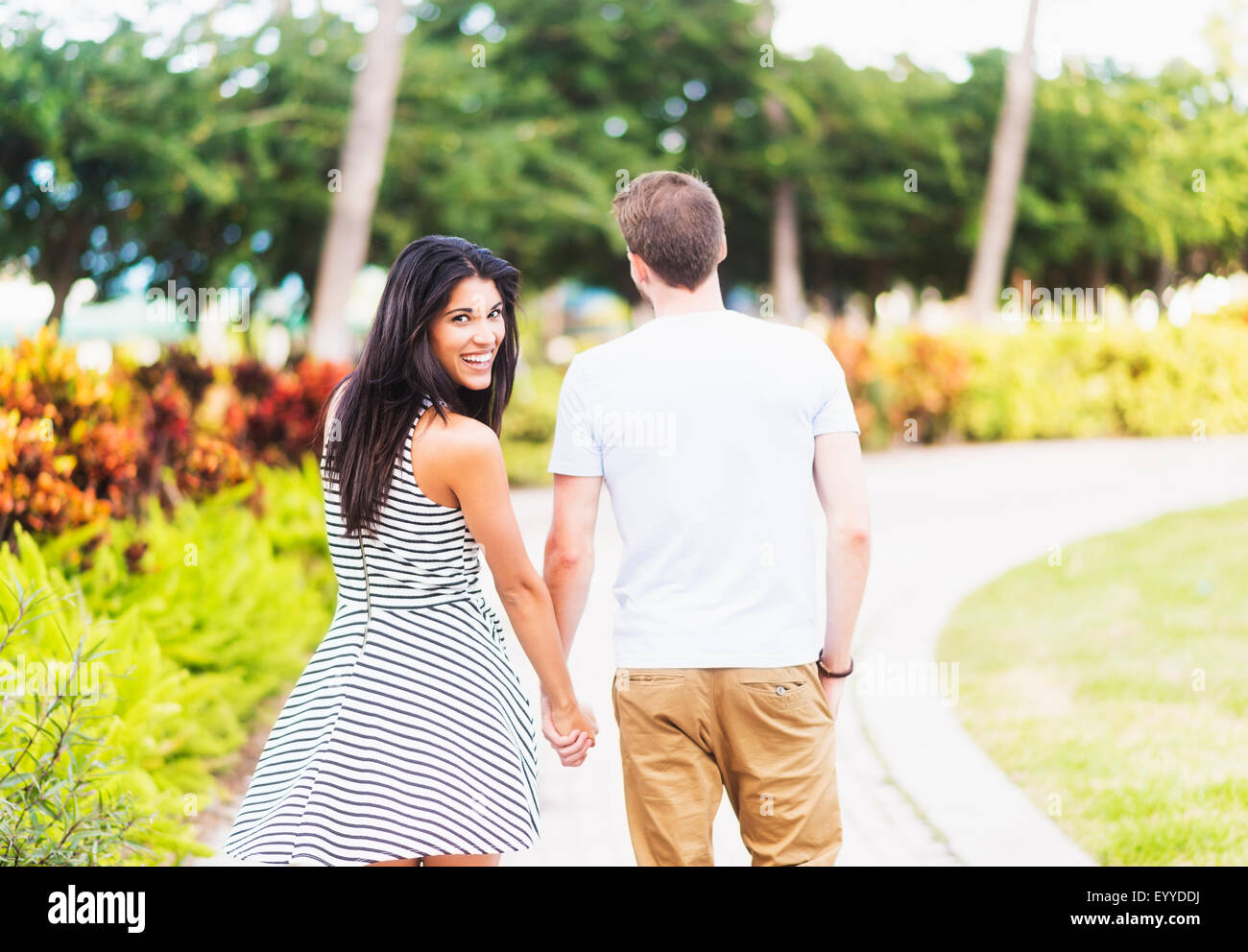 Smiling Hispanic couple walking in park Stock Photo - Alamy