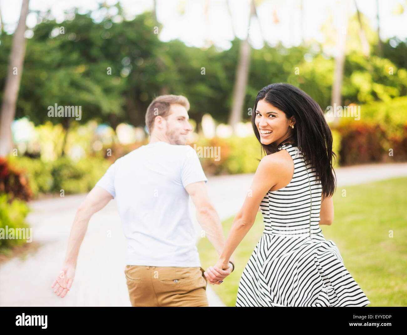 Smiling Hispanic couple walking in park Stock Photo - Alamy