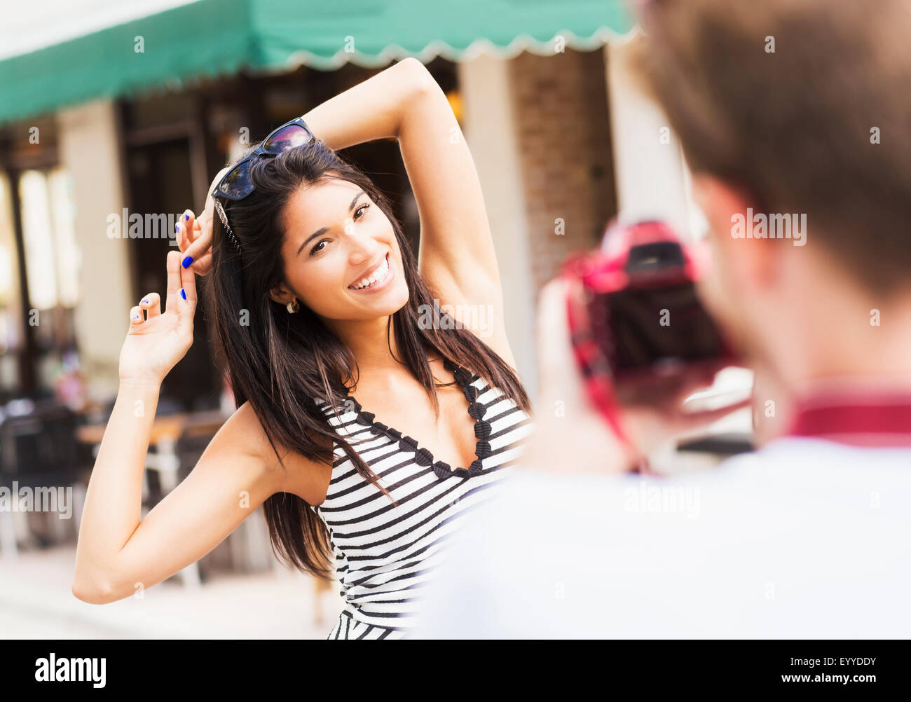 Hispanic man photographing girlfriend outdoors Stock Photo - Alamy