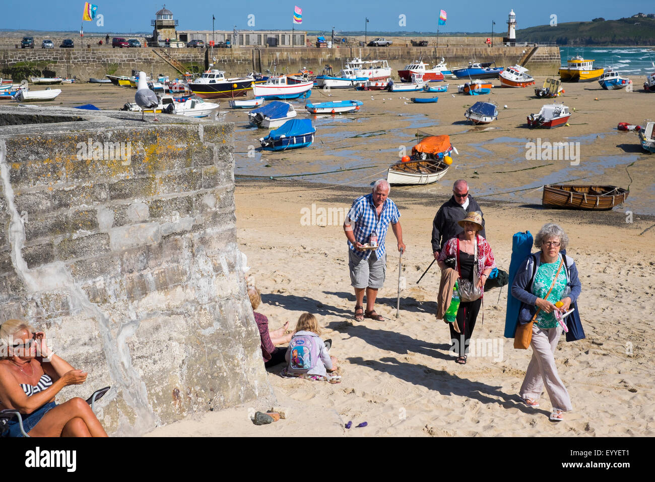 People walking on the beach beside St Ives harbour, Cornwall, England ...